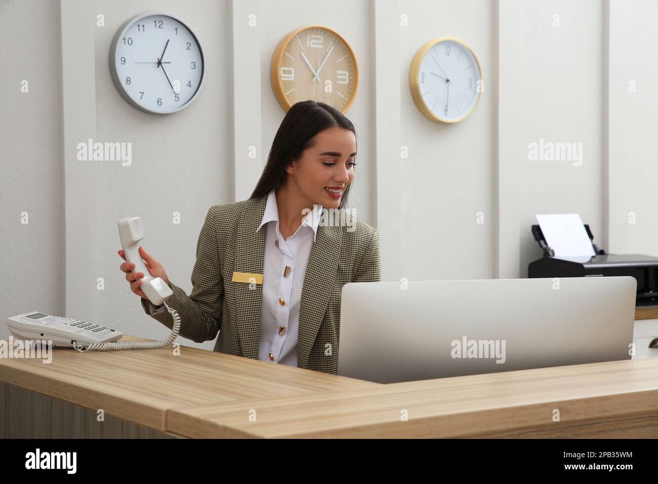 Beautiful receptionist working at counter in hotel Stock Photo - Alamy