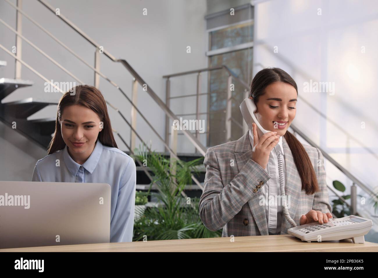 Female receptionists working at desk in hotel Stock Photo - Alamy