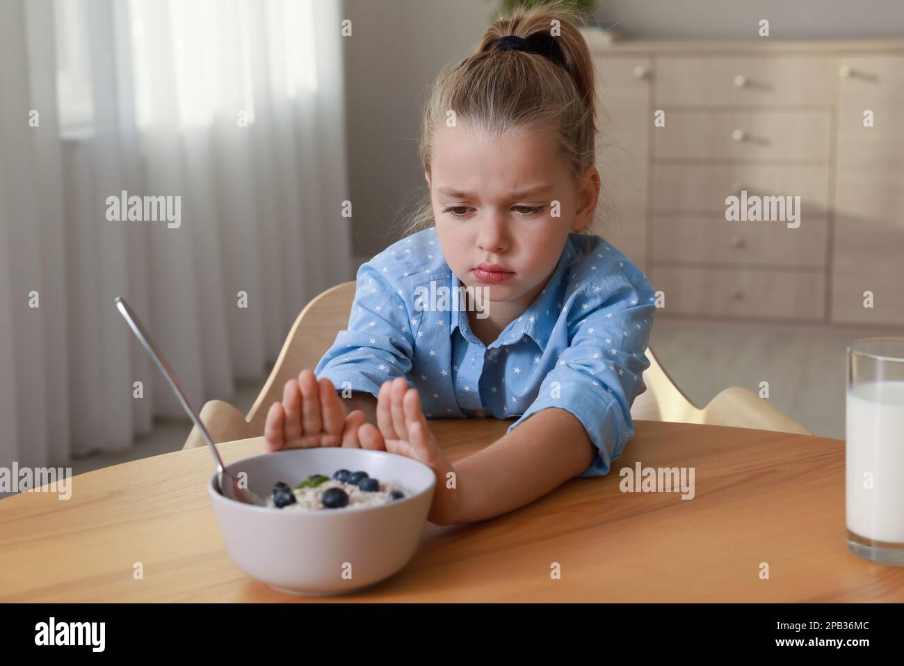 Cute little girl refusing to eat her breakfast at home Stock Photo - Alamy