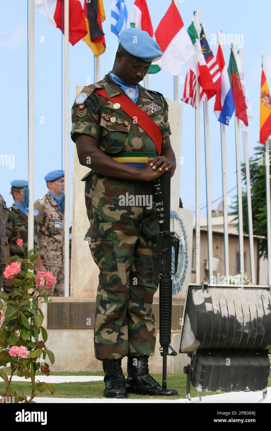 A U.N. peacekeeper bows his head in respect during a ceremony in the ...