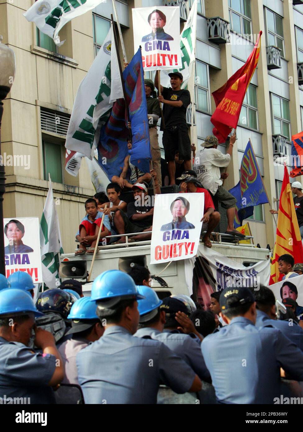 Protesters display a poster of President Gloria Macapagal Arroyo as ...