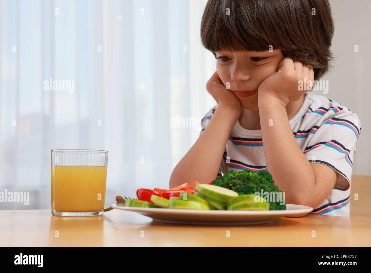 Cute little boy refusing to eat vegetables at home Stock Photo - Alamy