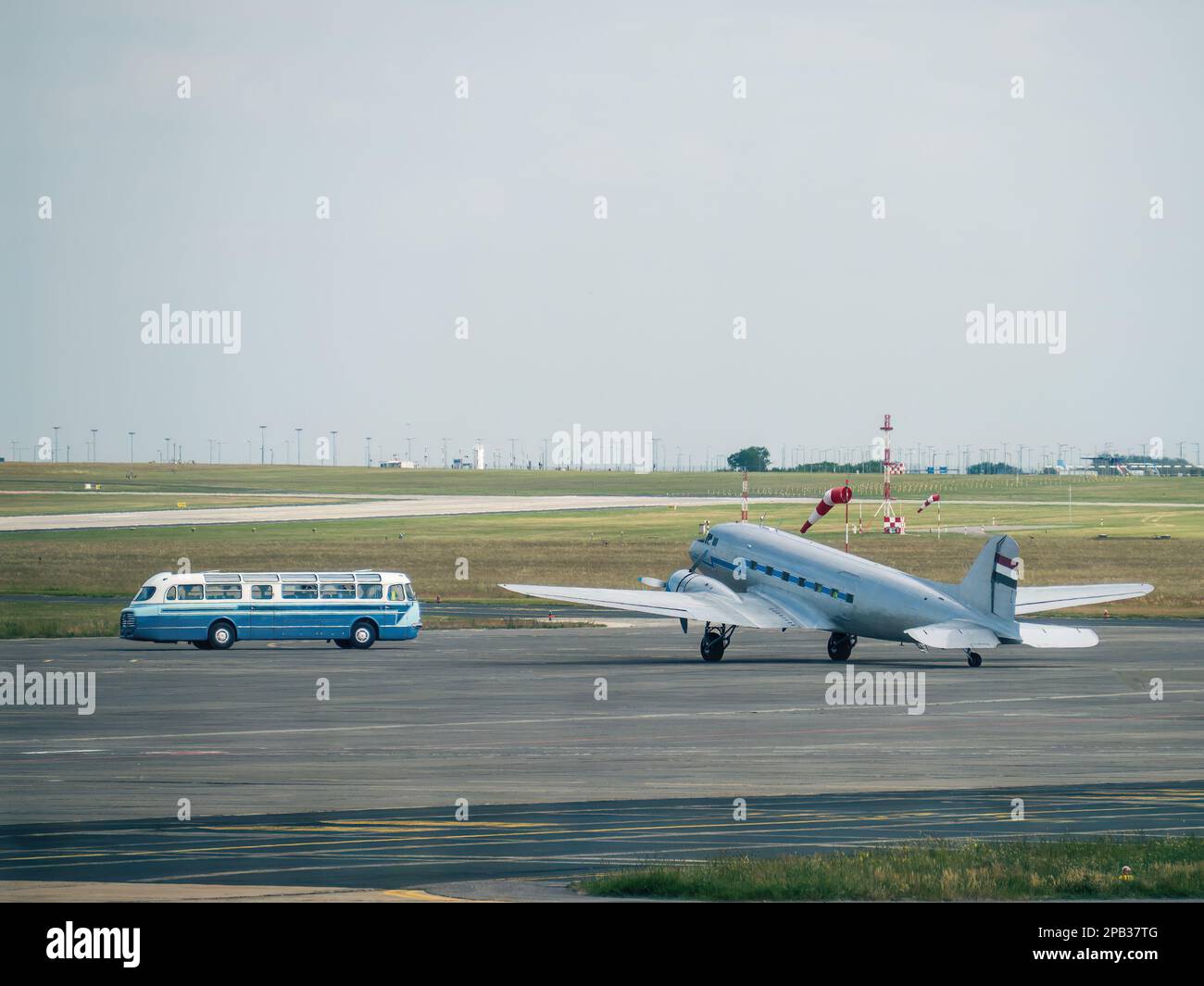 Retro vintage airliner passenger airplane and bus on a runway no people ...