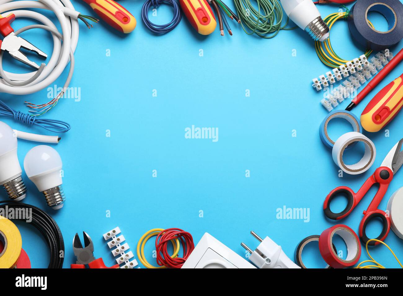 Frame of electrician's tools and accessories on light blue background ...