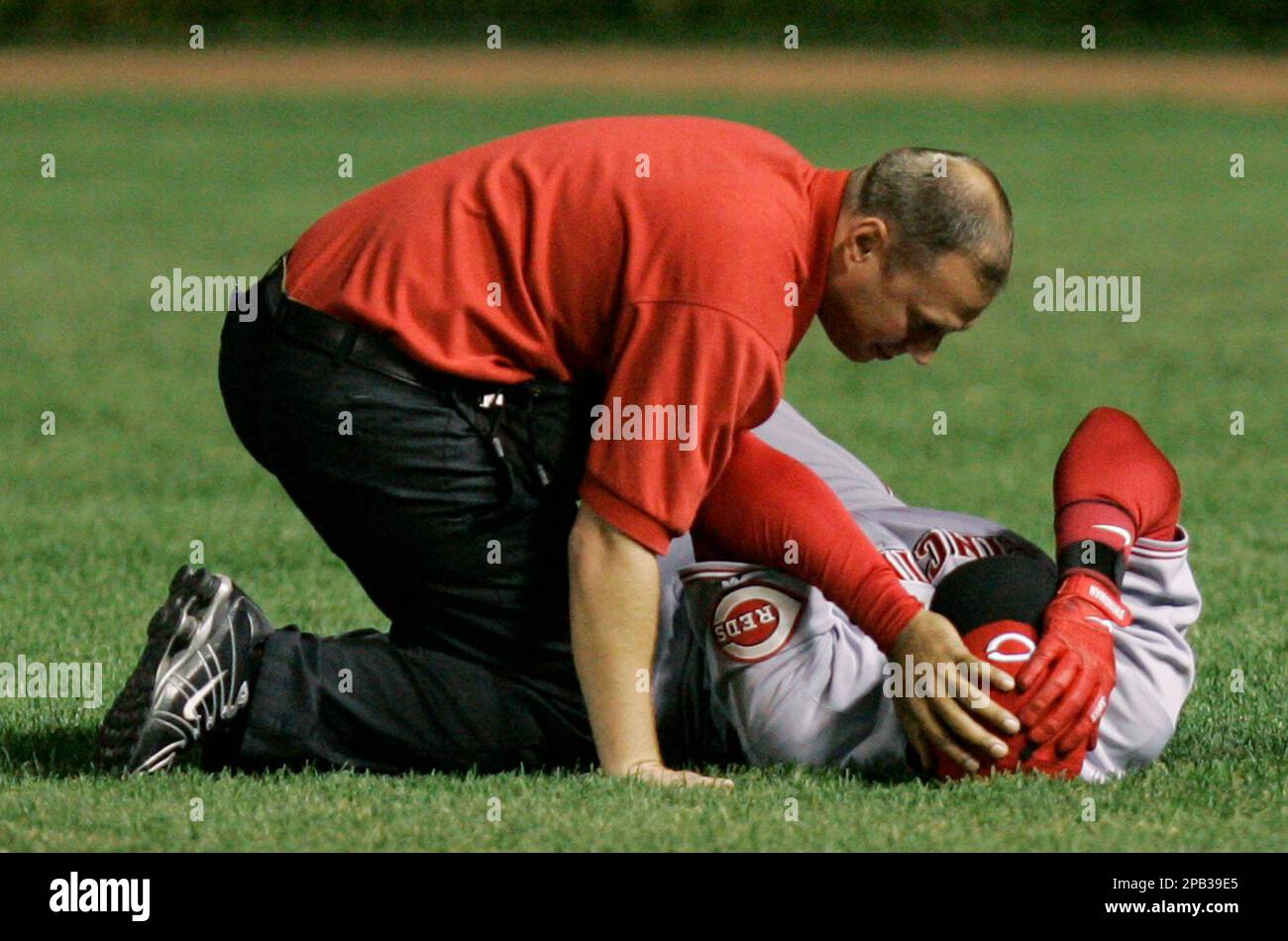 Cincinnati Reds assistant trainer Steve Baumann, left, attends to ...