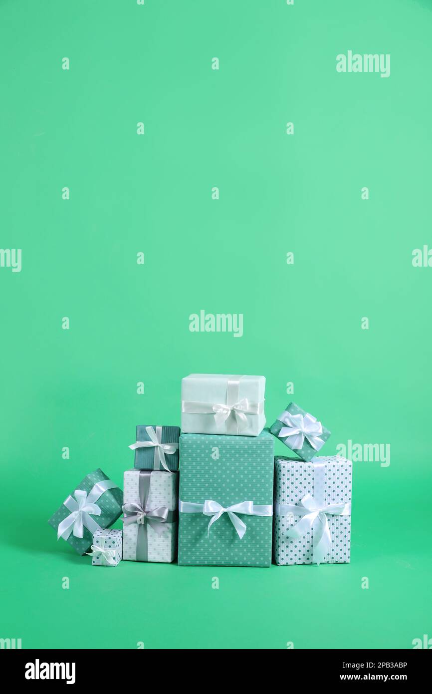 Many beautifully wrapped gift boxes on green background. Space for text ...