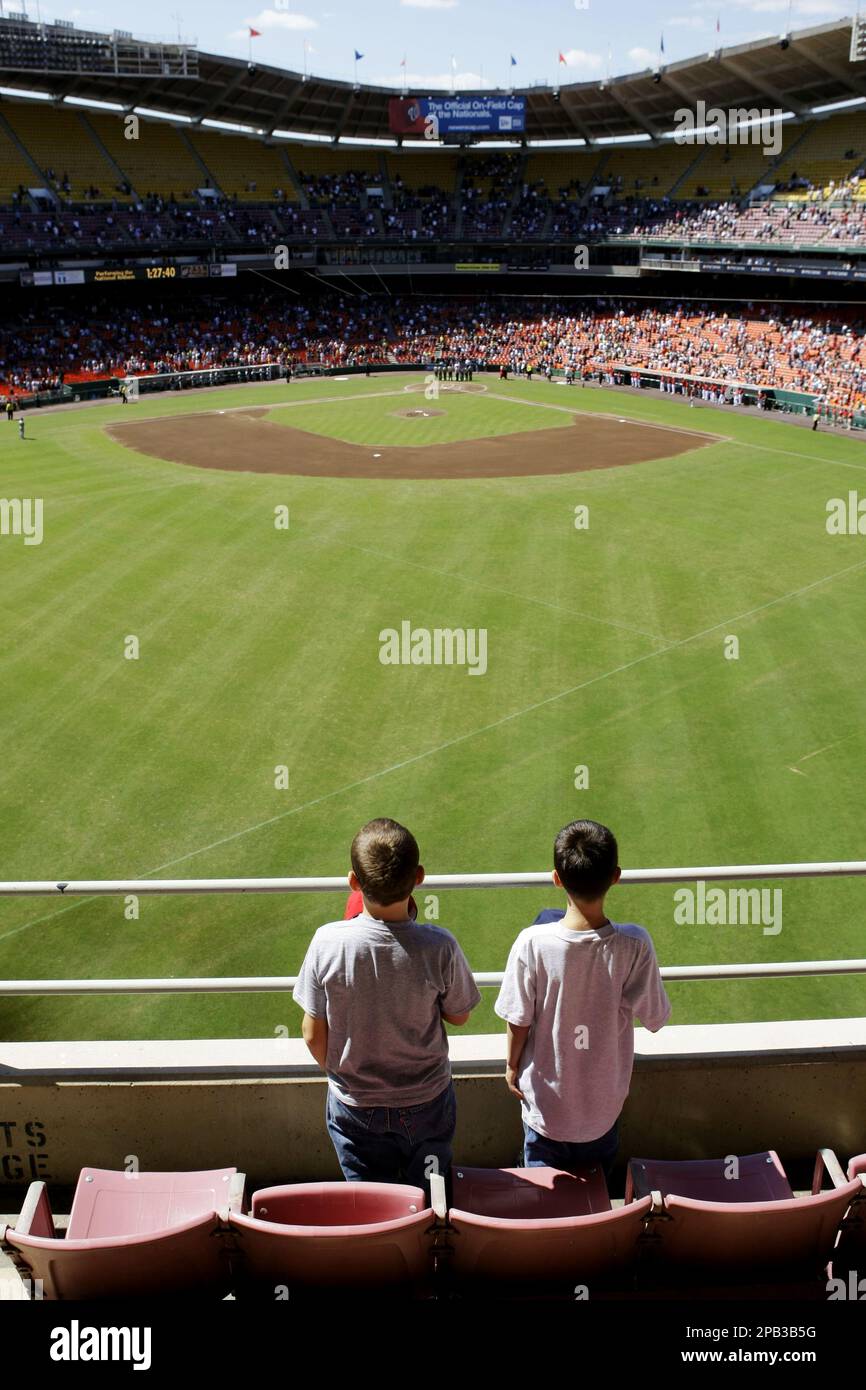 Two unidentified fans stand to the National Anthem in the centerfield ...