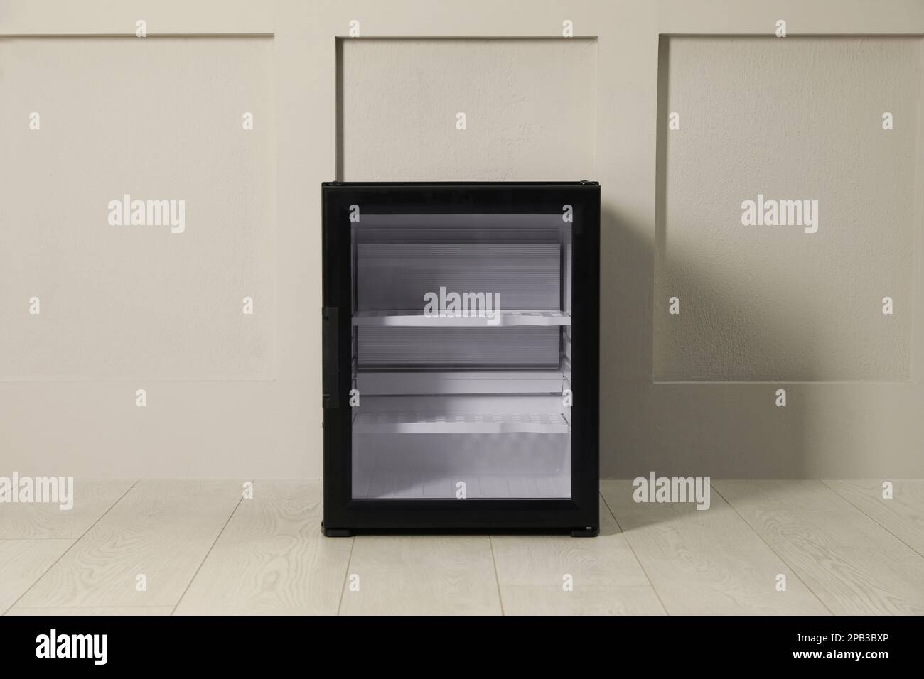 Empty mini bar with glass door near beige wall indoors Stock Photo - Alamy