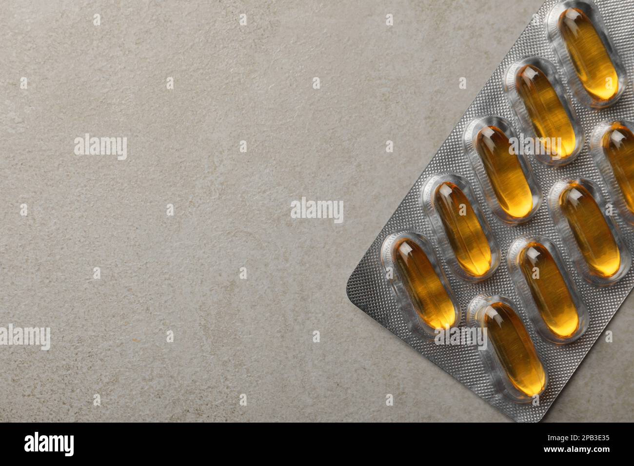 Dietary supplement capsules in blister pack on grey table, top view ...