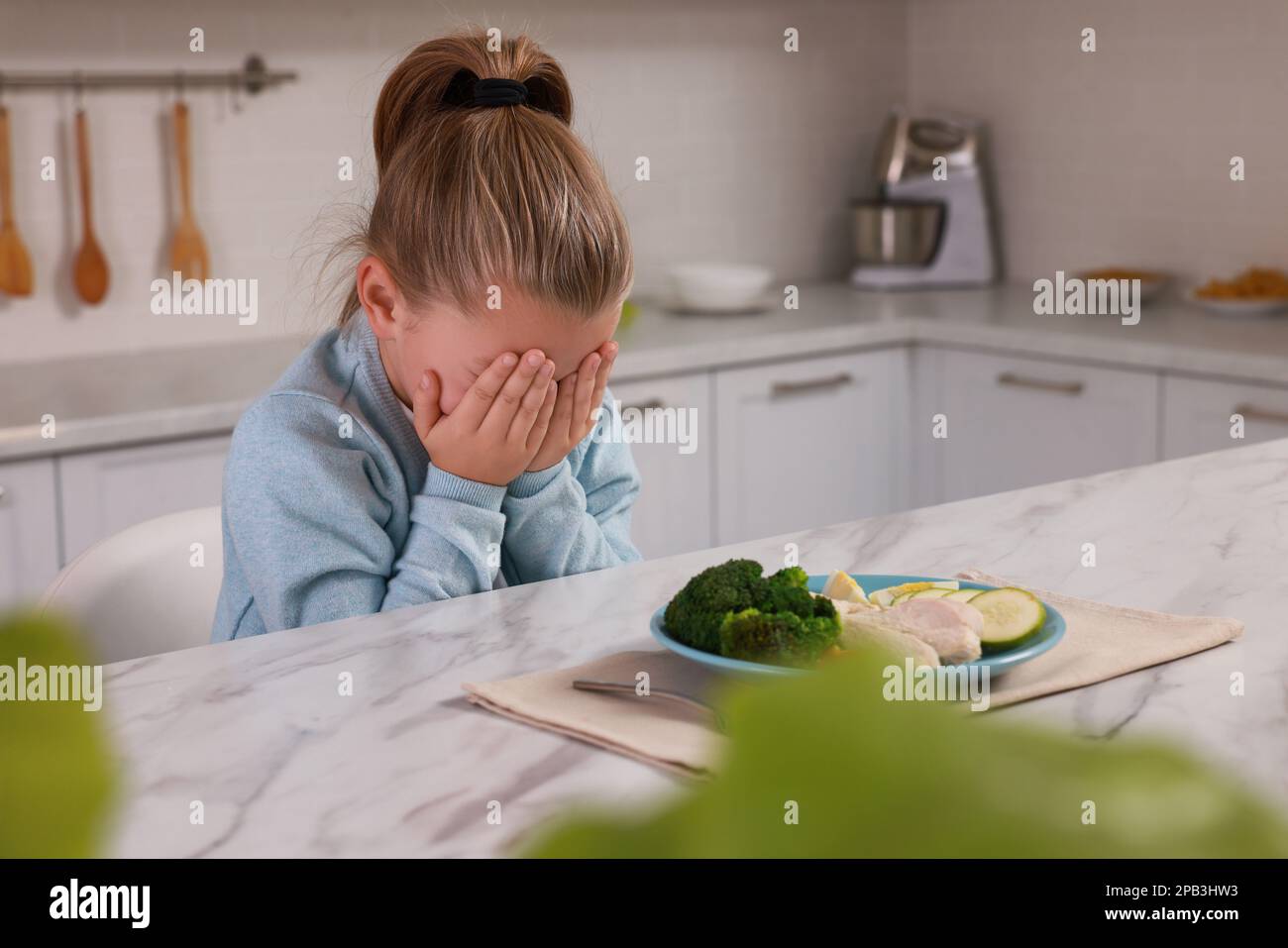 Cute little girl crying and refusing to eat dinner in kitchen Stock ...