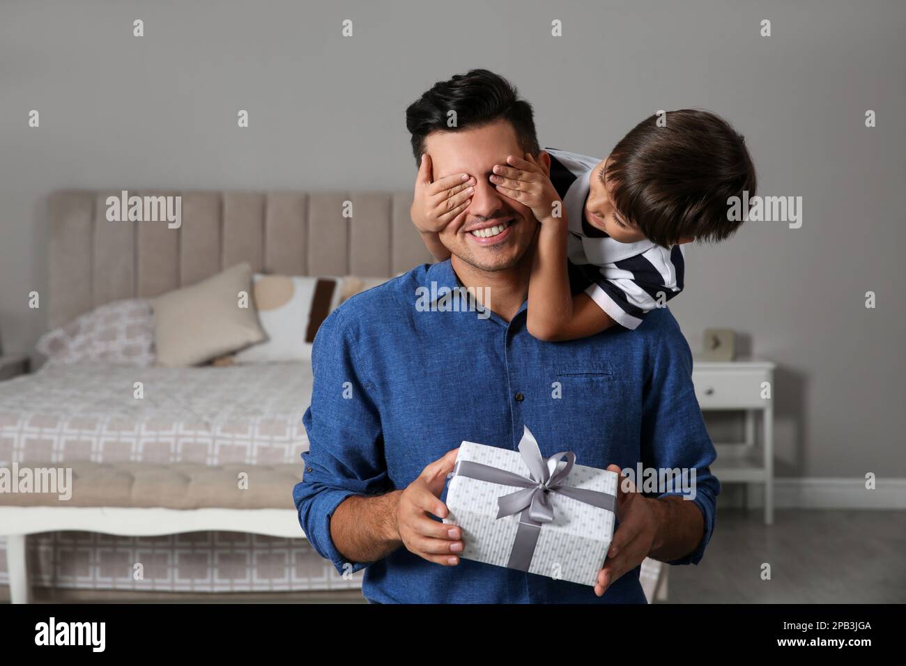 Man receiving gift for Father's Day from his son at home Stock Photo ...