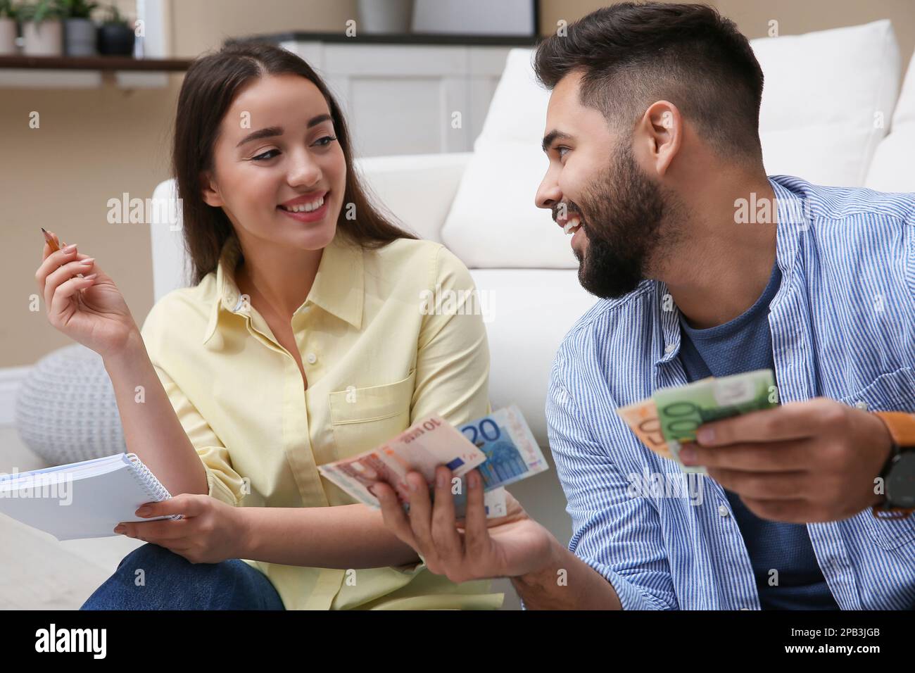 Smiling couple counting money hi-res stock photography and images - Alamy