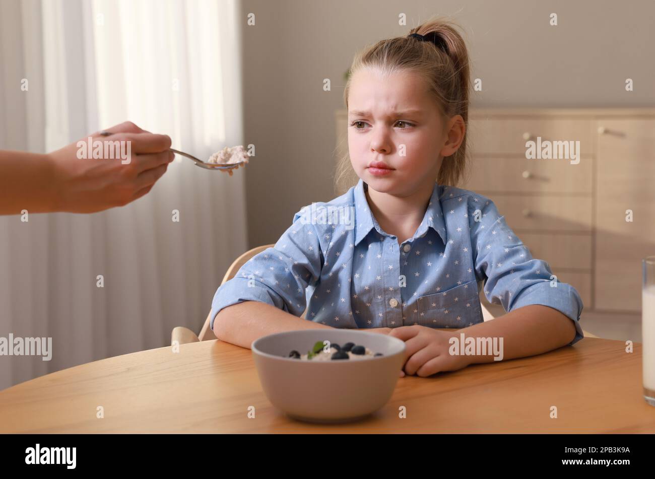 Cute little girl refusing to eat her breakfast at home Stock Photo - Alamy