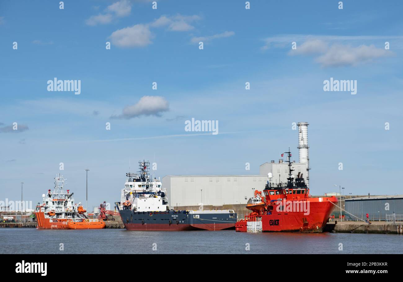 Three marine vessels moored outside industrial units on the River Yare ...