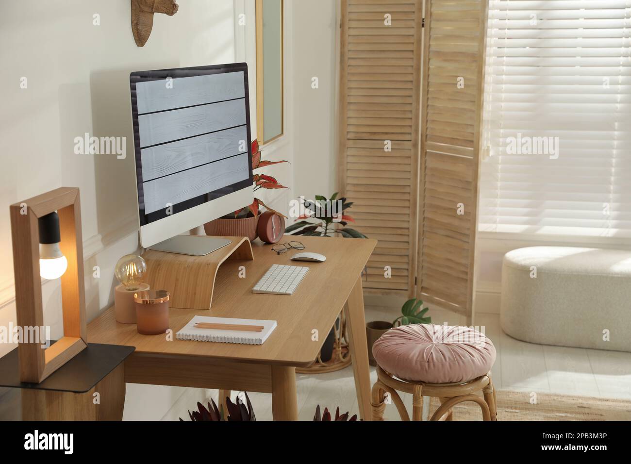 Comfortable workplace with modern computer and beautiful plants in room ...