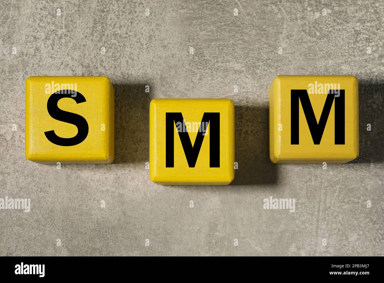 Yellow cubes with letters SMM on grey stone background, flat lay Stock ...