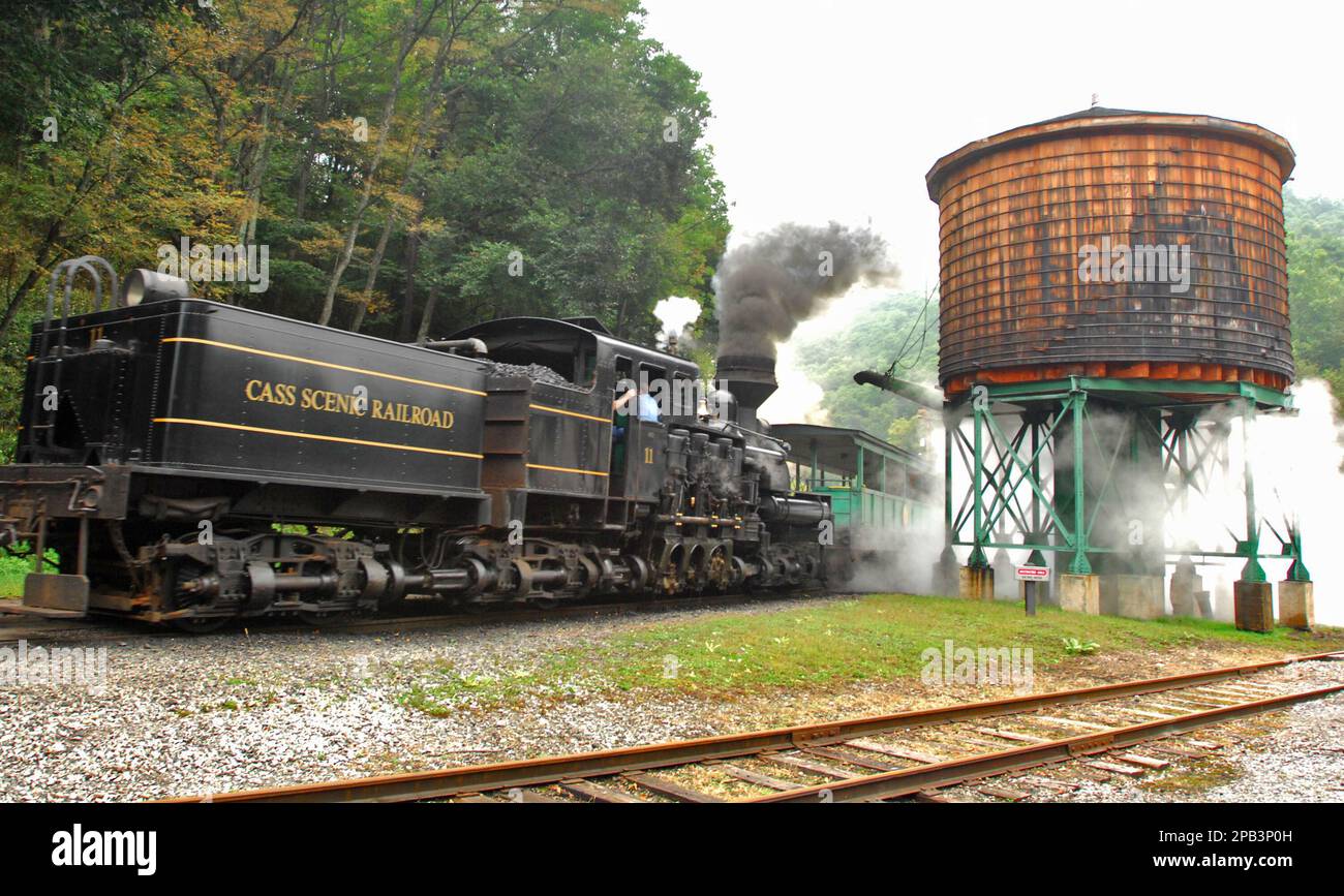 A passenger train from the Cass Scenic Railroad passes the water tower ...