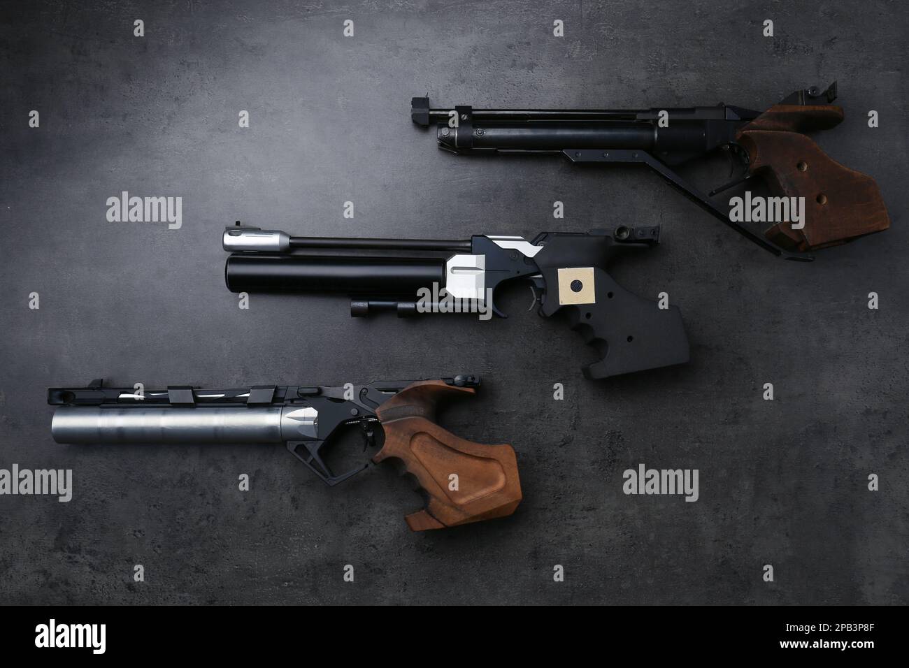 Many different sport pistols on black table, flat lay. Professional ...