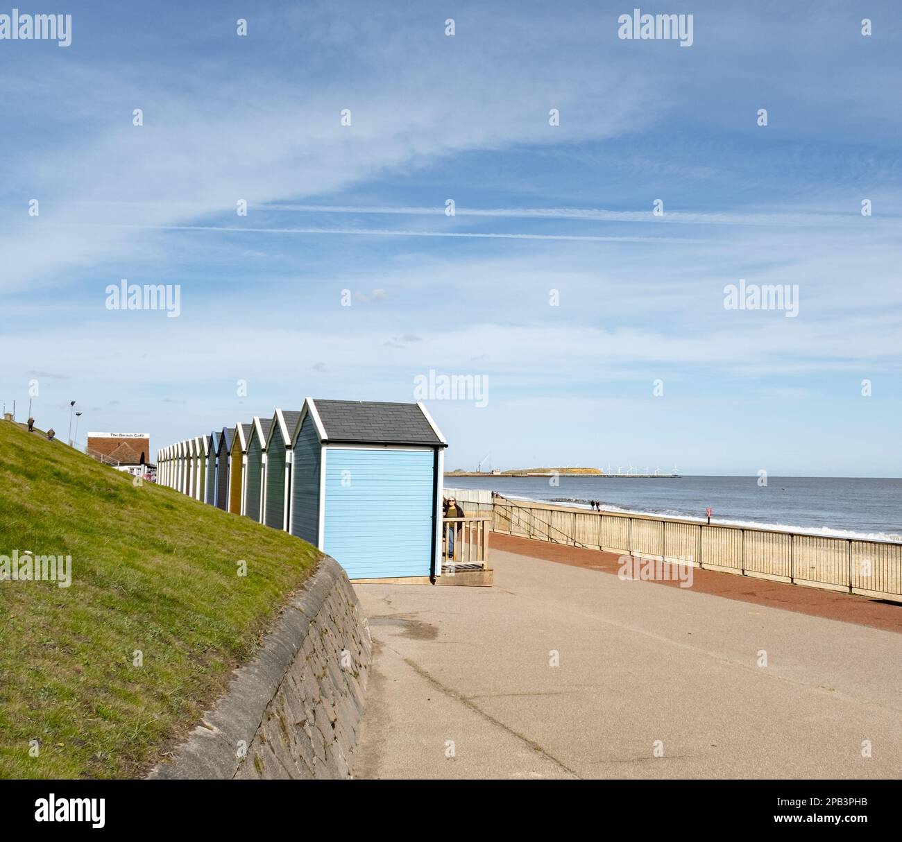 Colourful beach huts on the promenade or esplanade in the seaside town ...