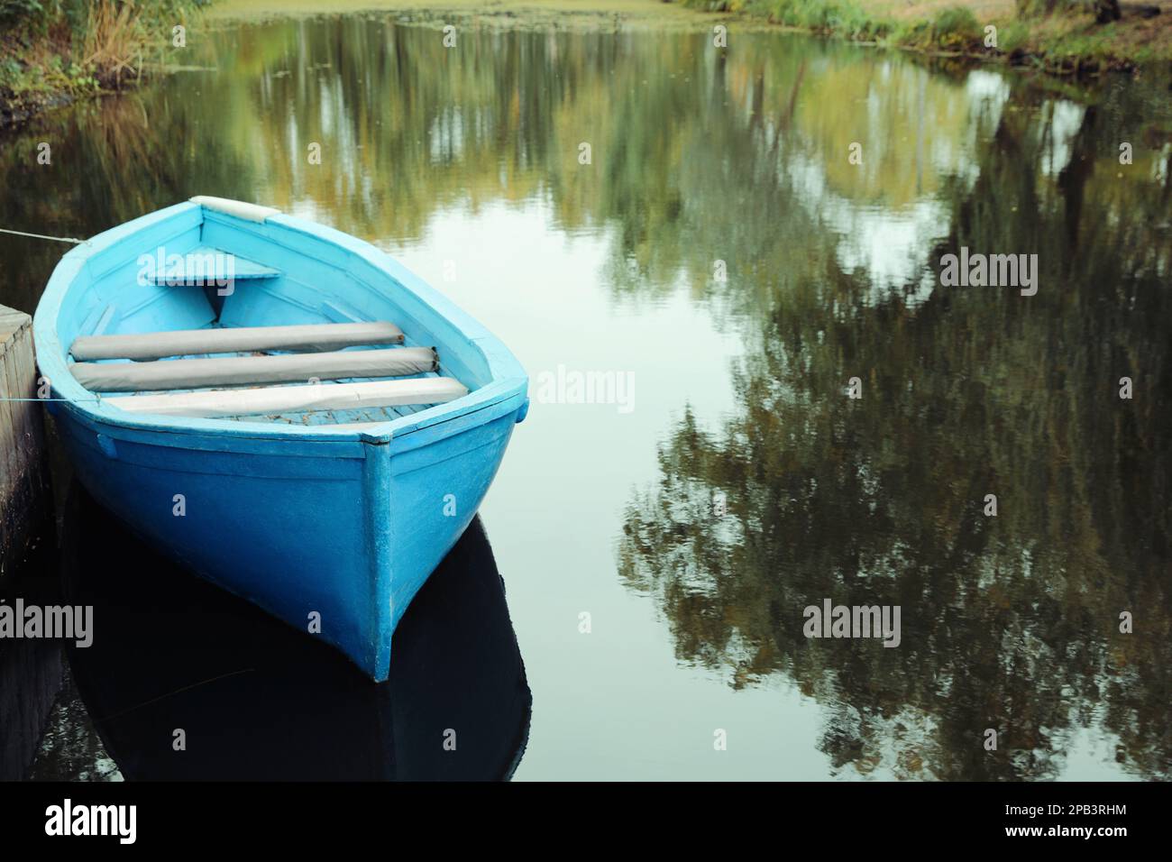 Light blue wooden boat on lake, space for text Stock Photo - Alamy