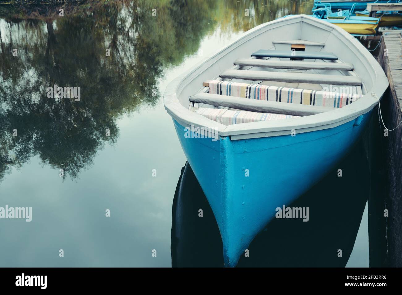 Light blue wooden boat on lake, space for text Stock Photo - Alamy