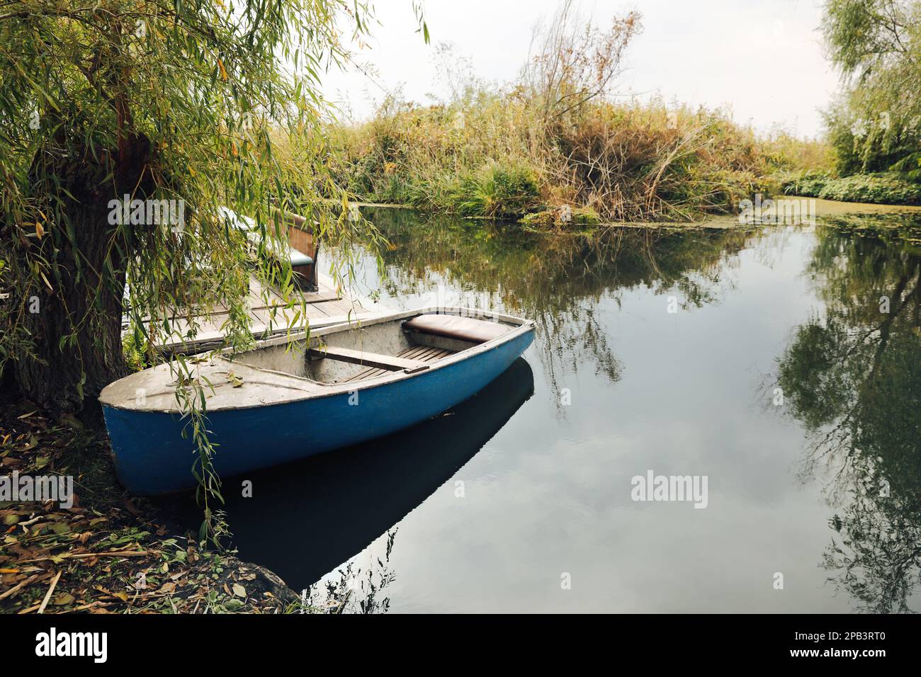 Light blue wooden boat on lake near pier, space for text Stock Photo ...
