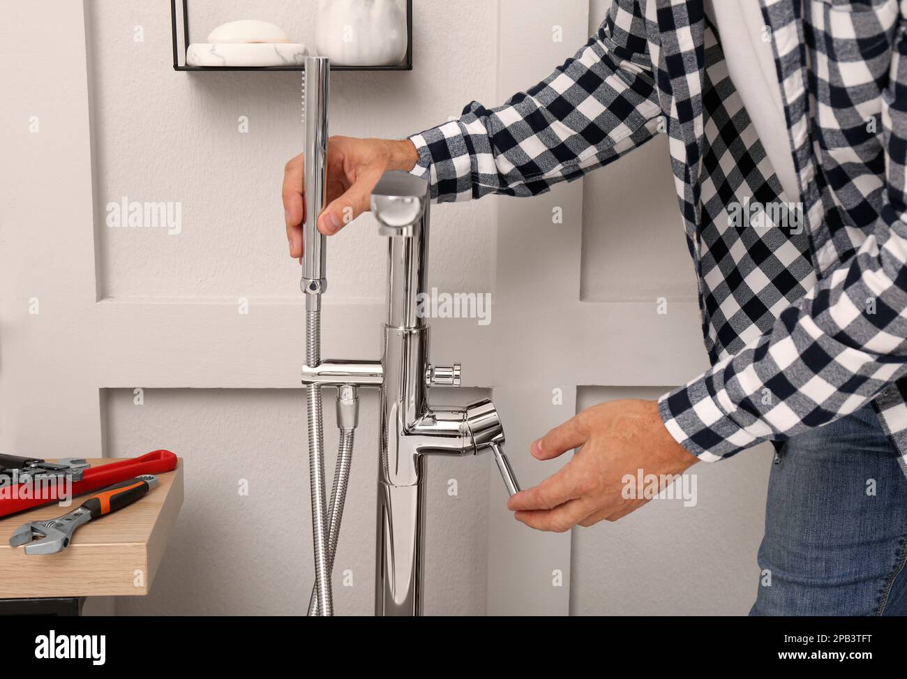 Man installing water tap with shower head in bathroom, closeup Stock ...