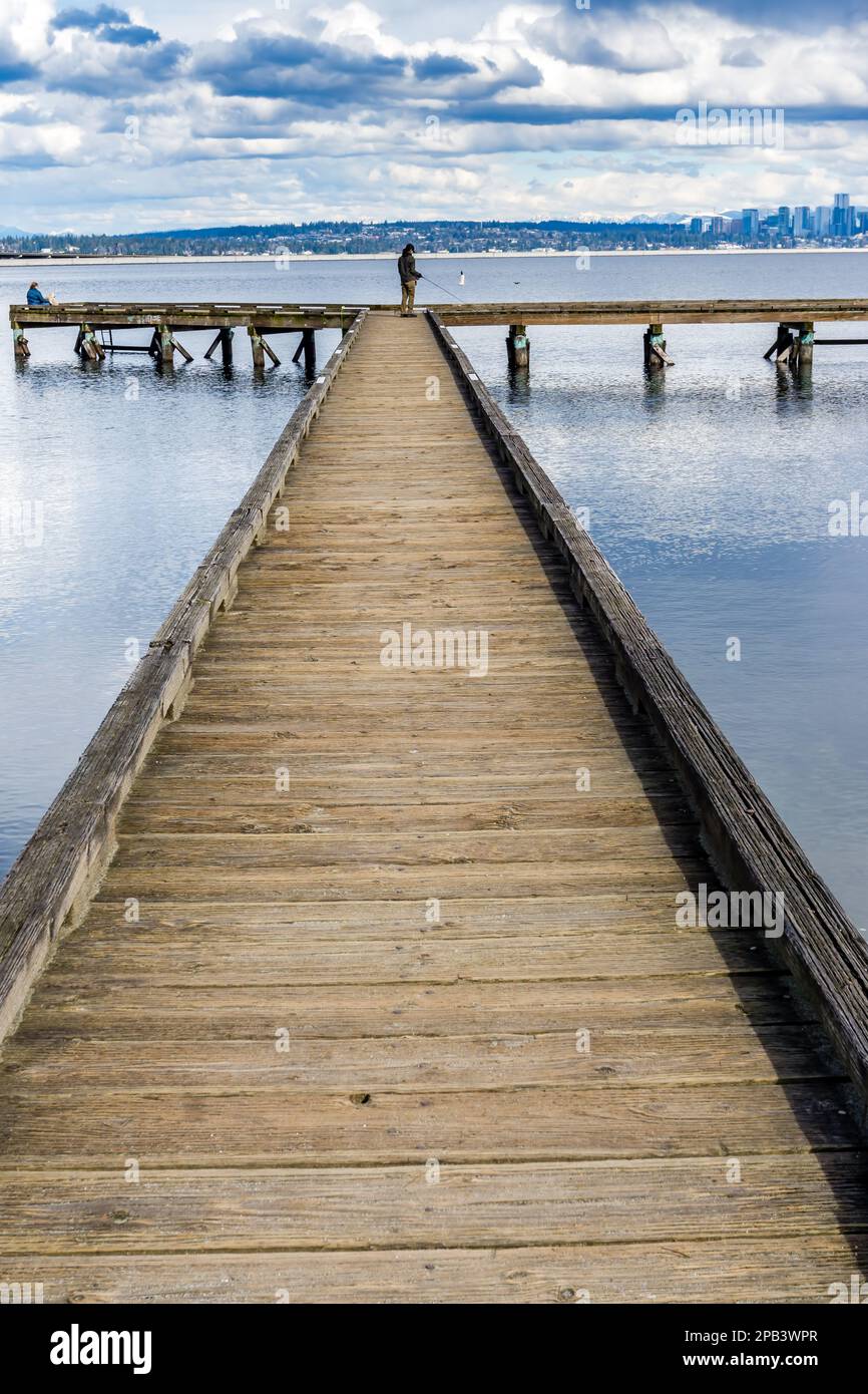 Clouds hang over a scene of Lake Washington with a highway and pier in ...