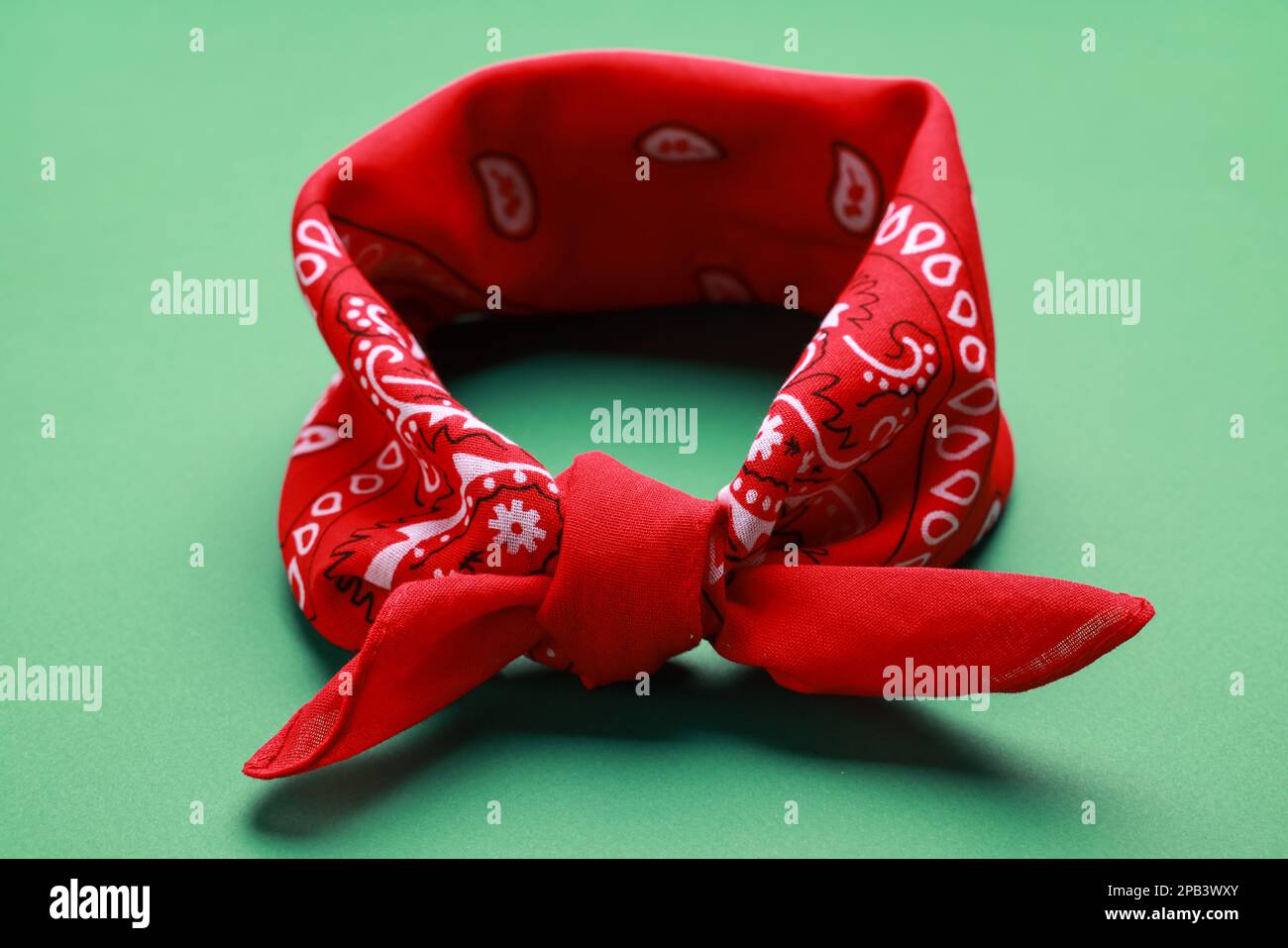 Tied red bandana with paisley pattern on light green background closeup Stock Photo Alamy