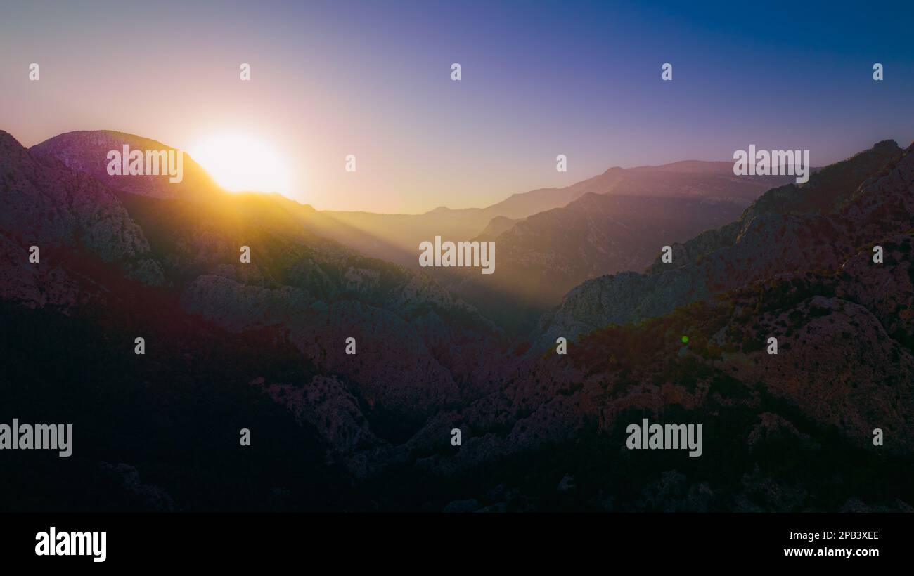 red sun rising through the mountains Stock Photo - Alamy