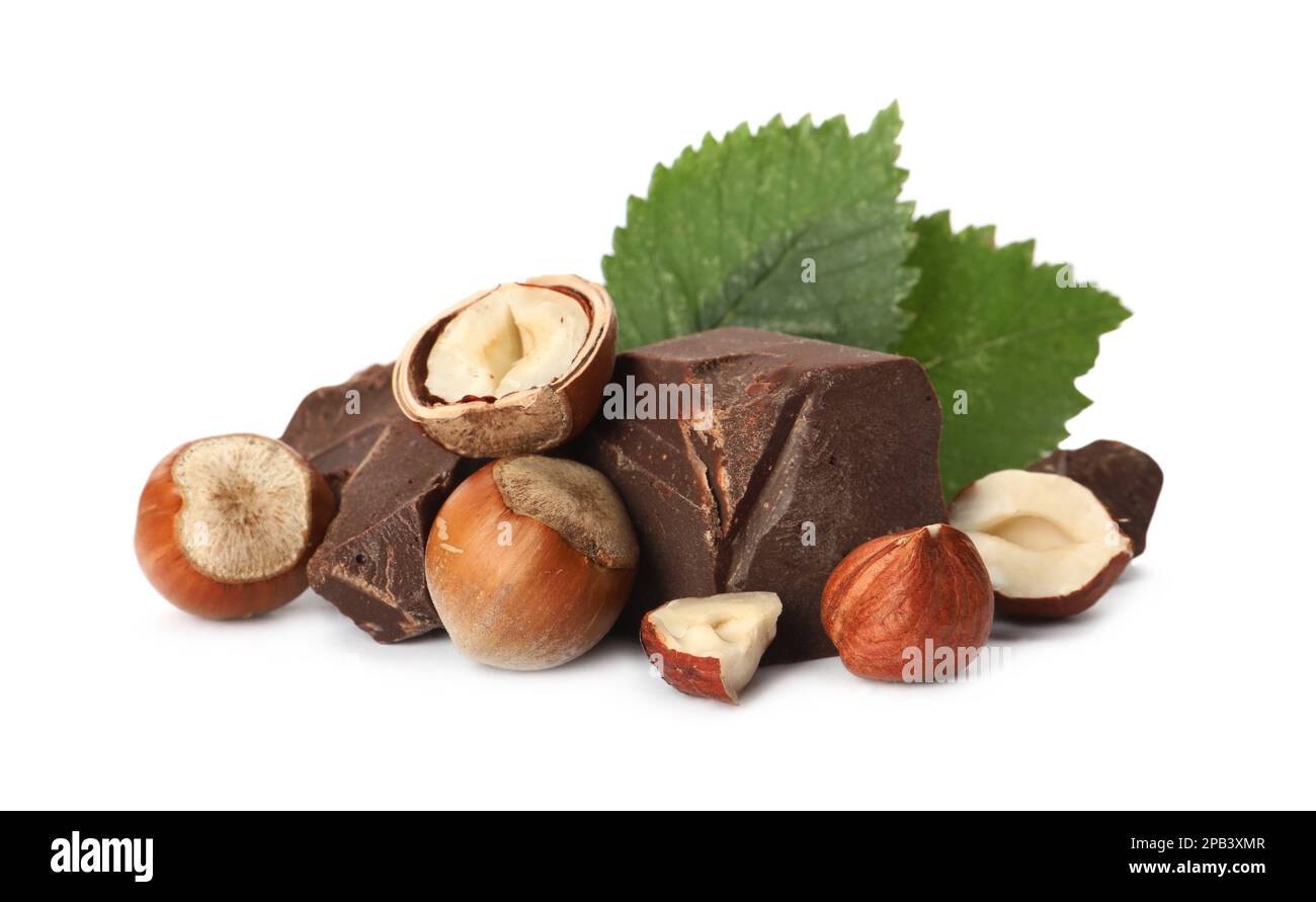 Delicious chocolate chunks with hazelnuts and green leaves on white ...