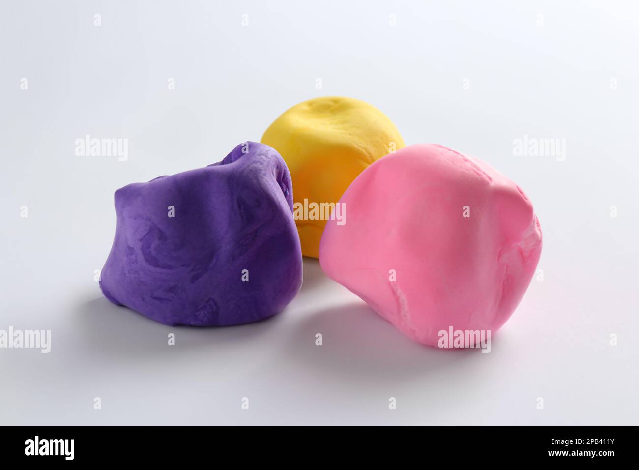 Different color play dough on white background Stock Photo - Alamy