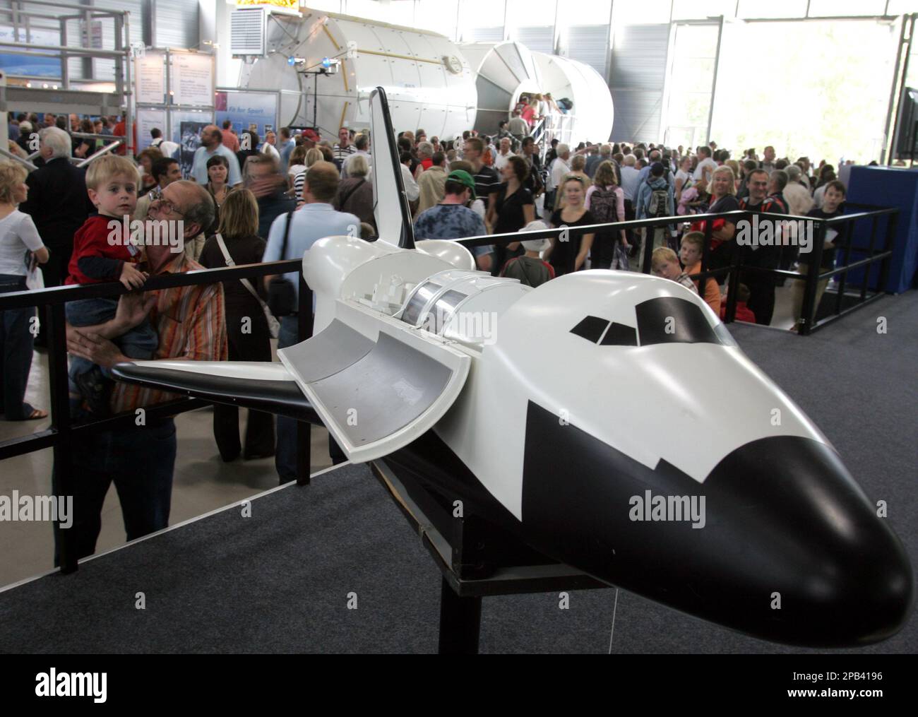 Visitors take a look at the scale model of a Space Shuttle and other aeronautic exhibits during ...