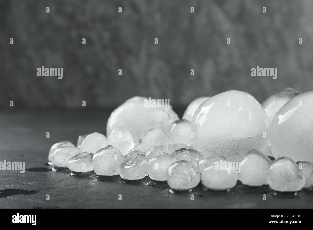 Many melting ice balls on dark table, space for text Stock Photo - Alamy