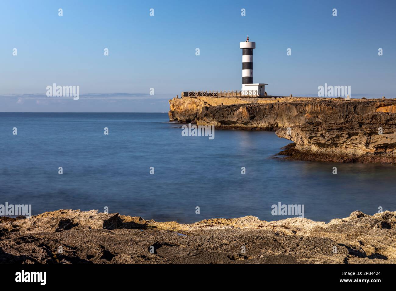 Black and white striped lighthouse of Colonia de Sant Jordi on a rocky ...