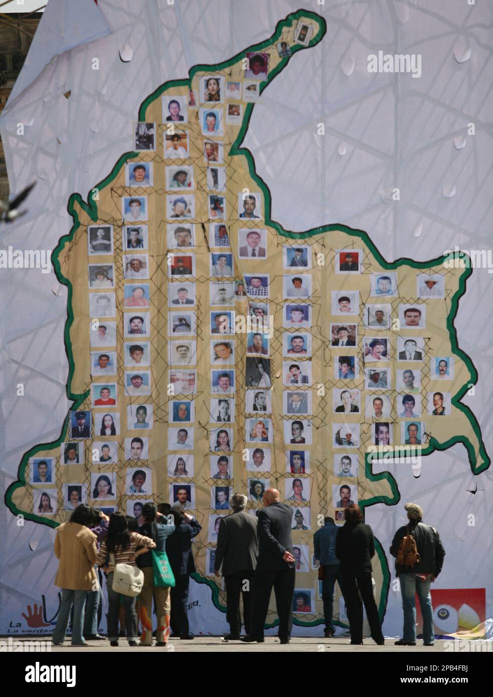 People look at a map of Colombia filled with pictures of people who are ...