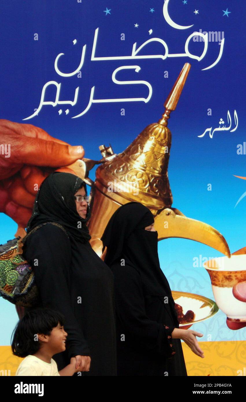Unidentified Bahraini family walk by a huge poster Wednesday, Sept. 12 ...