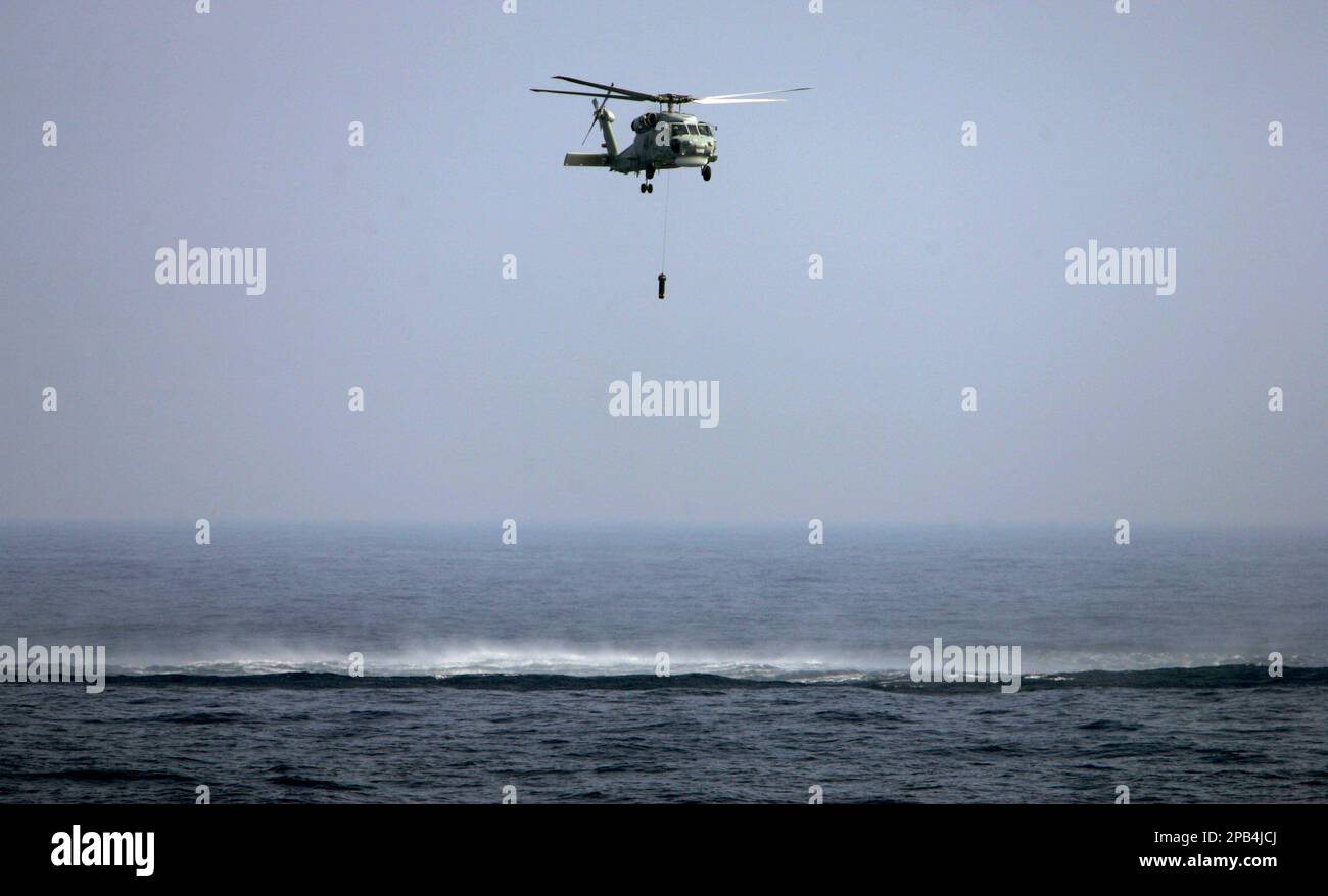 A Taiwanese navy helicopter lowers a submarine detection device during ...