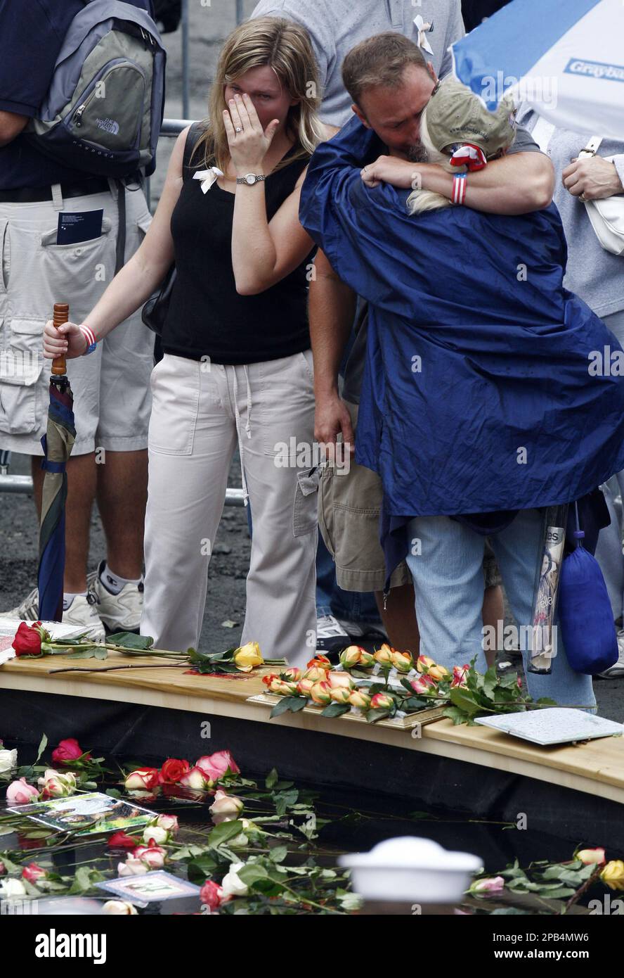 People embrace next to a reflecting pool at the base of the site World ...
