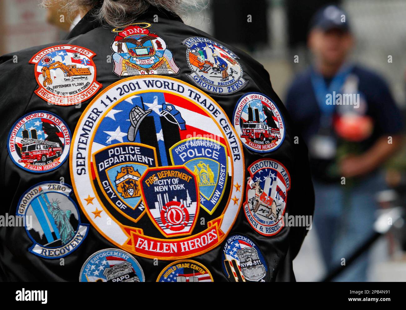 A man wears a jacket honoring rescue workers at Ground Zero during ...