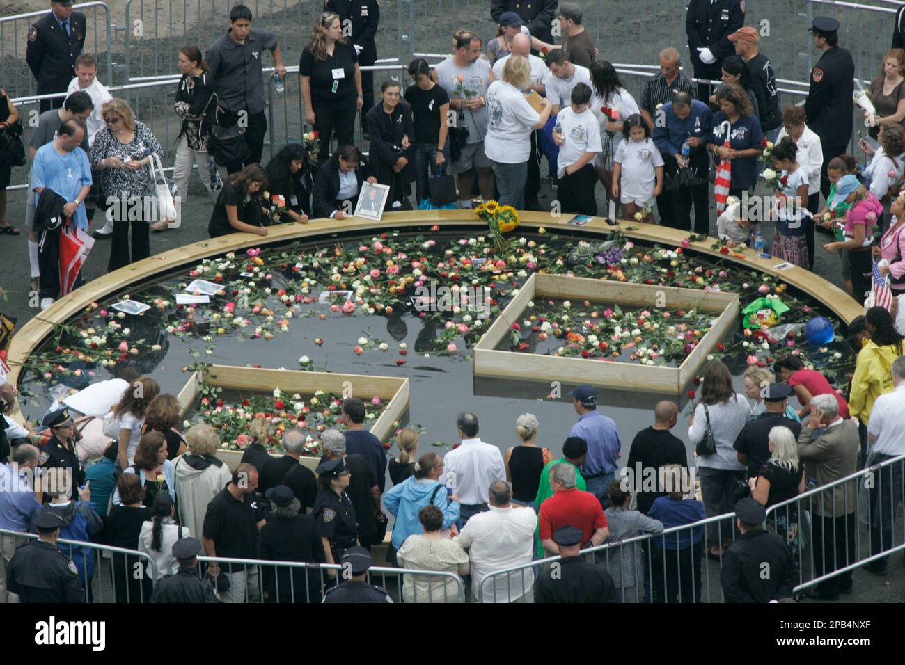 Family members place flowers and take a moment at the reflecting pool ...