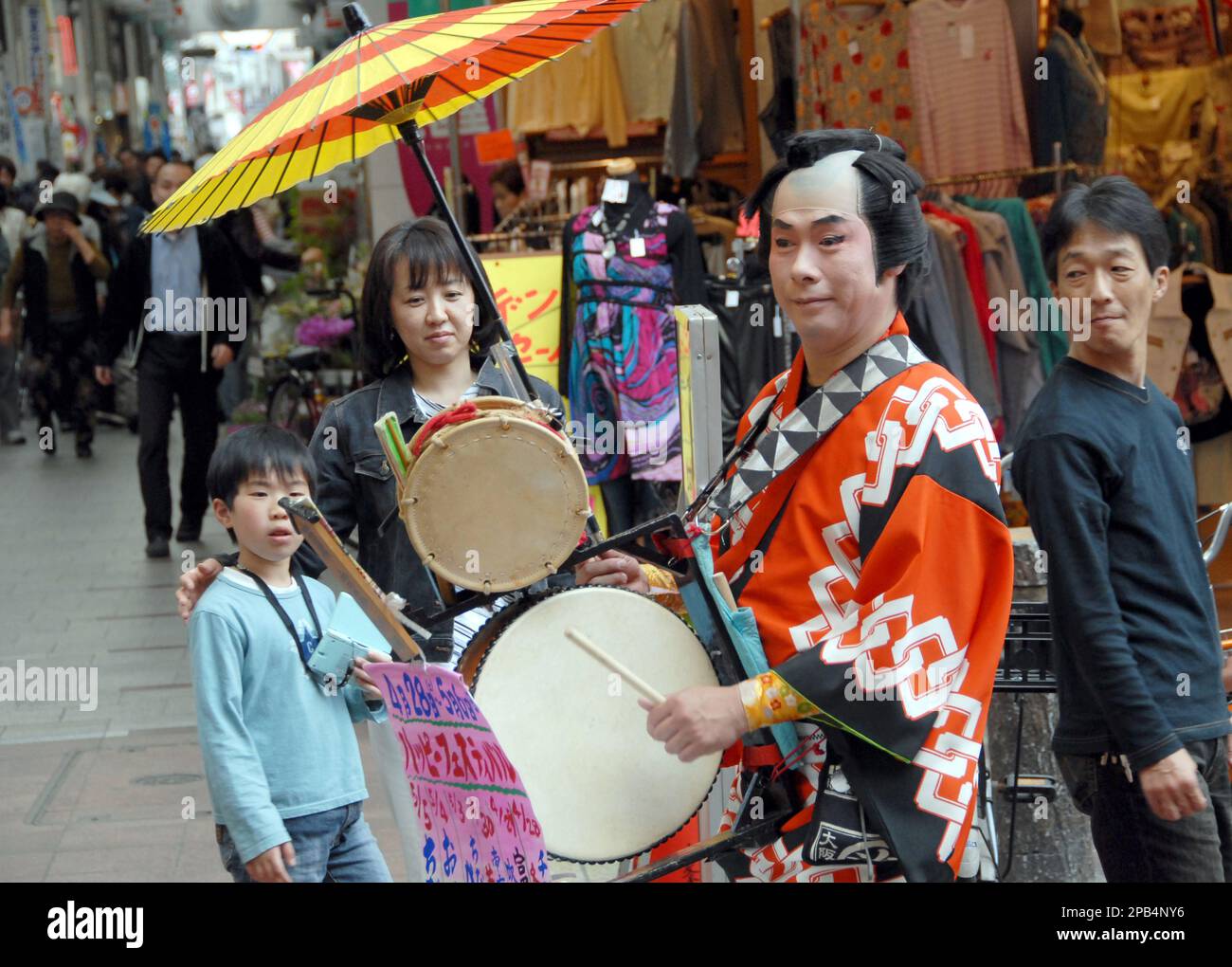** APN ADVANCE FOR SUNDAY, SEPT. 16 ** Weekend shoppers look at Chindonya Yosuke Takada beating ...