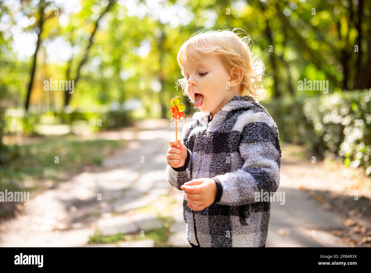 Funny child with candy lollipop, little boy eating big sugar lollipop ...