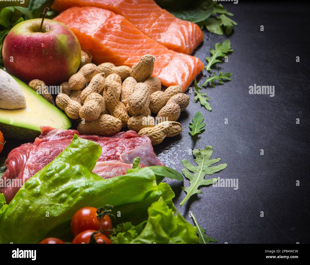 Fresh vegetables, fruits, fish, meat, nuts on black chalk board ...