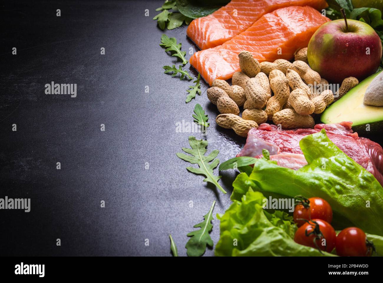 Fresh vegetables, fruits, fish, meat, nuts on black chalk board ...