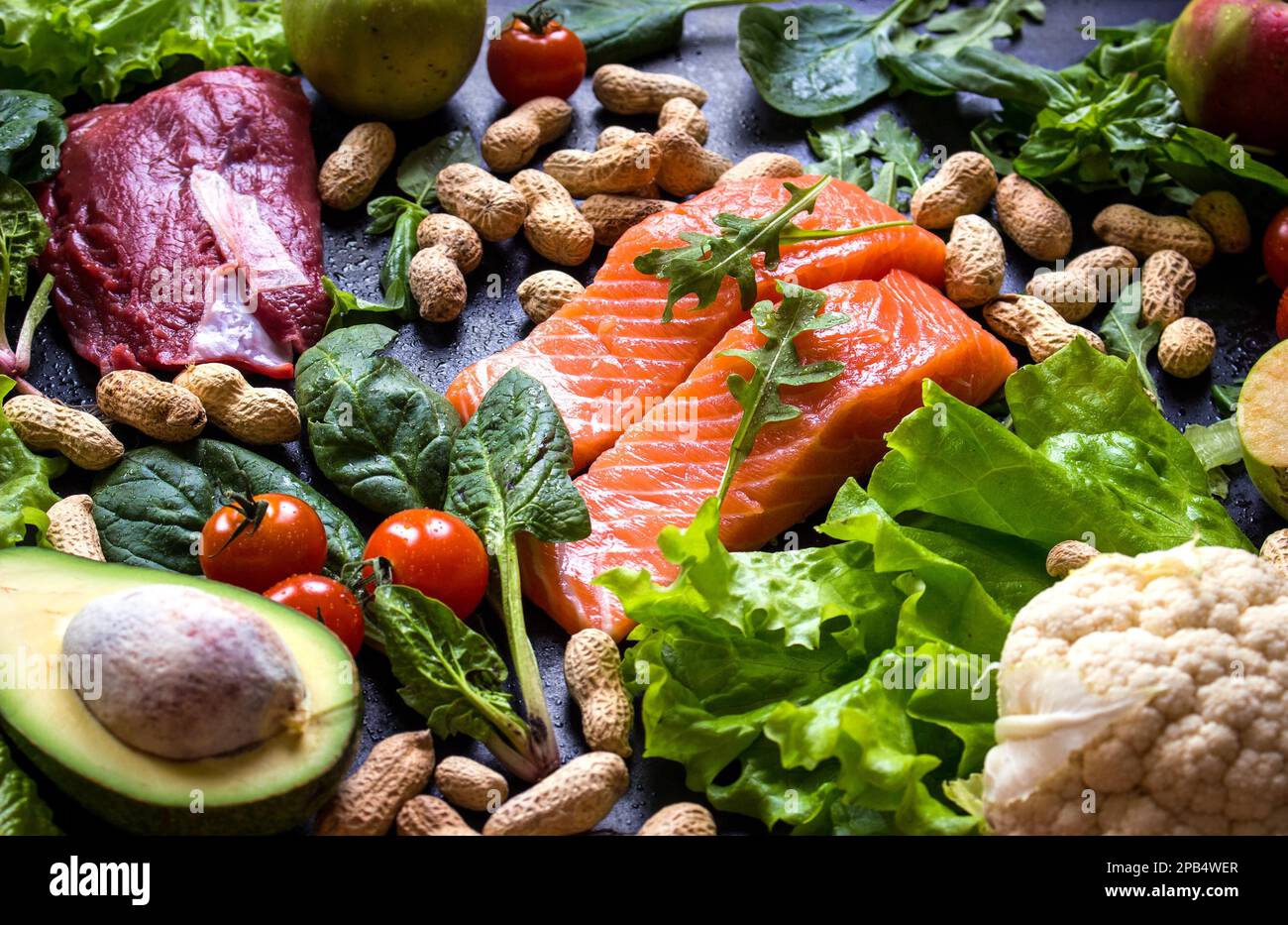Fresh fish, meat, vegetables, fruits, nuts on black chalk board ...