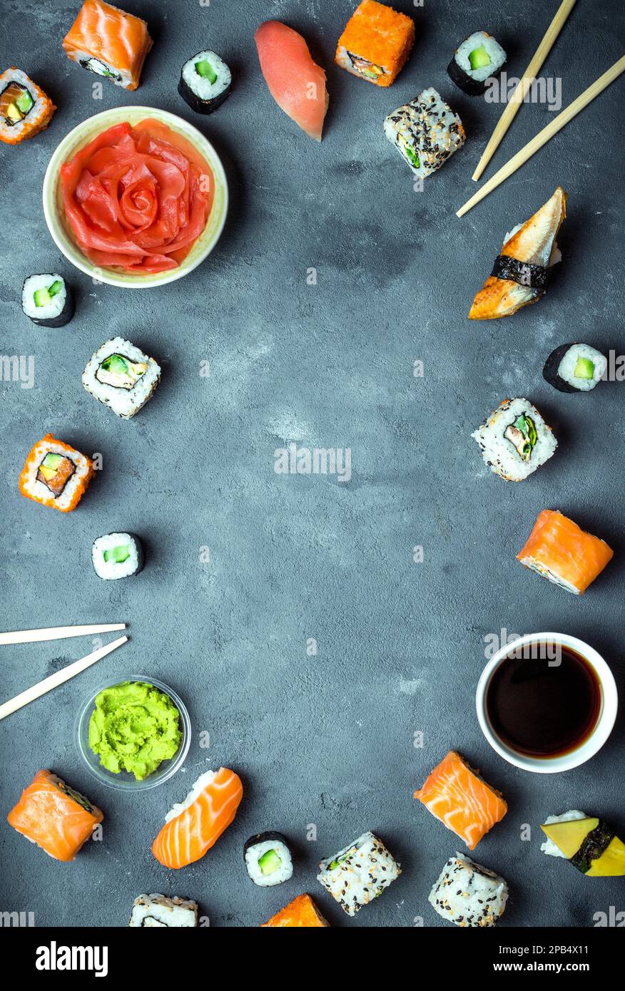 Japanese sushi on a dark background. Sushi rolls, nigiri, maki, pickled ginger, wasabi, soy ...