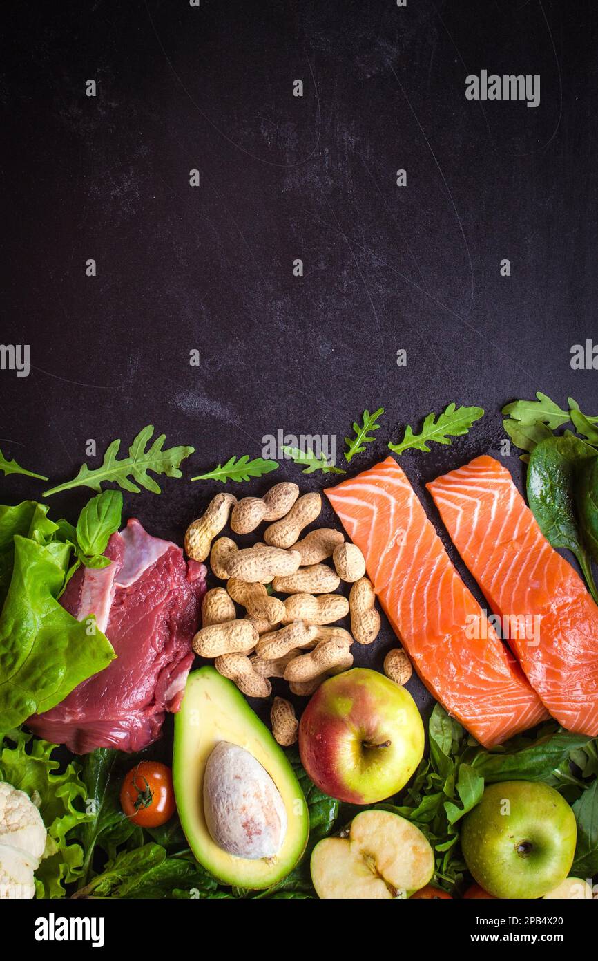 Fresh vegetables, fruits, fish, meat, nuts on black chalk board ...
