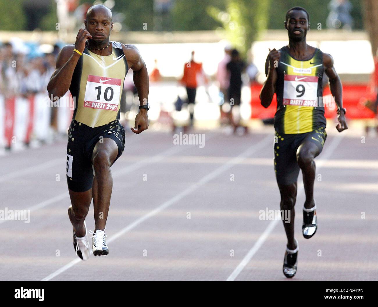 Asafa Powell of Jamaica, left, on his way to set the new world record in the 100 meters dash ...