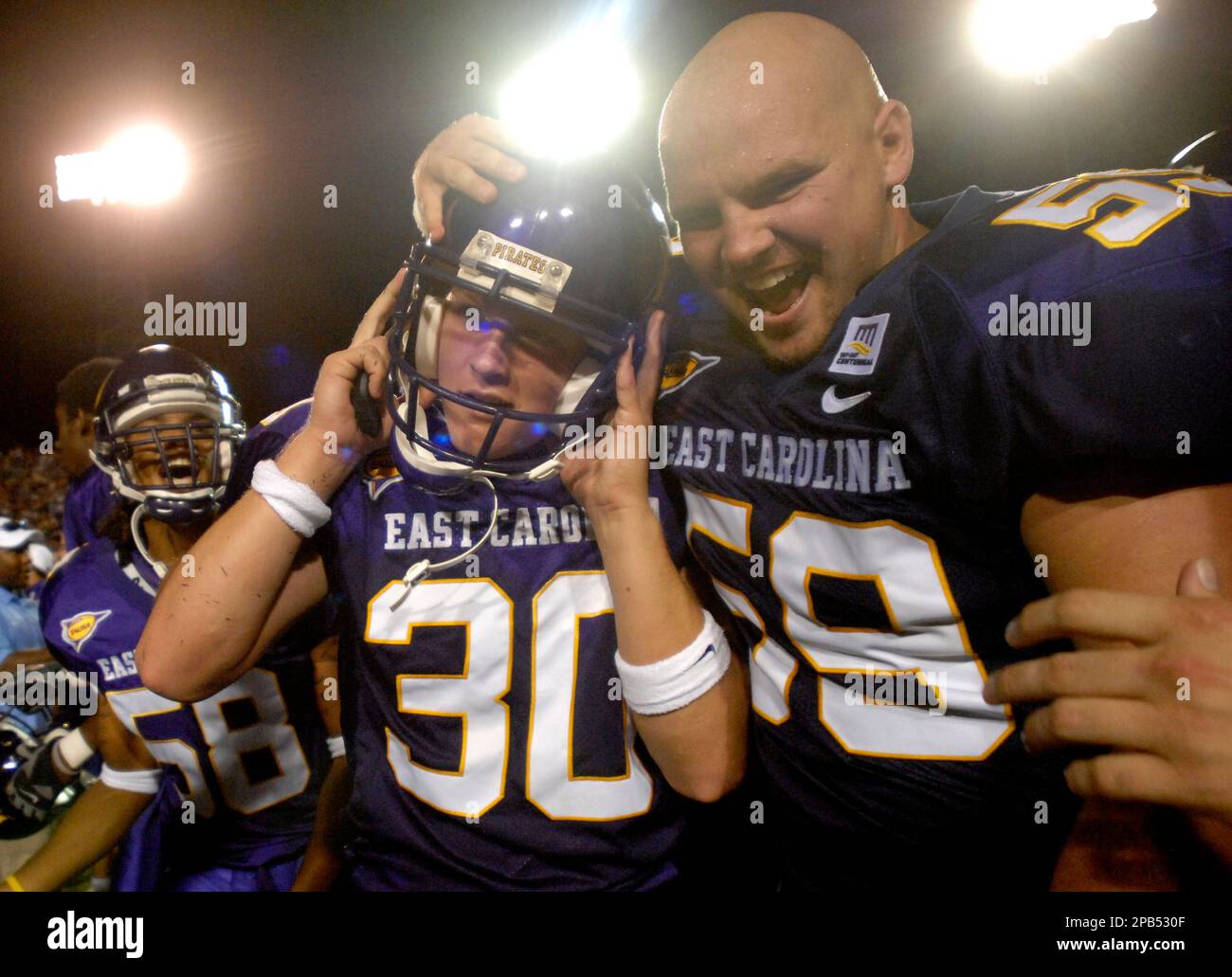 East Carolina kicker Ben Hartman (30) is hugged by teammate Wilson ...